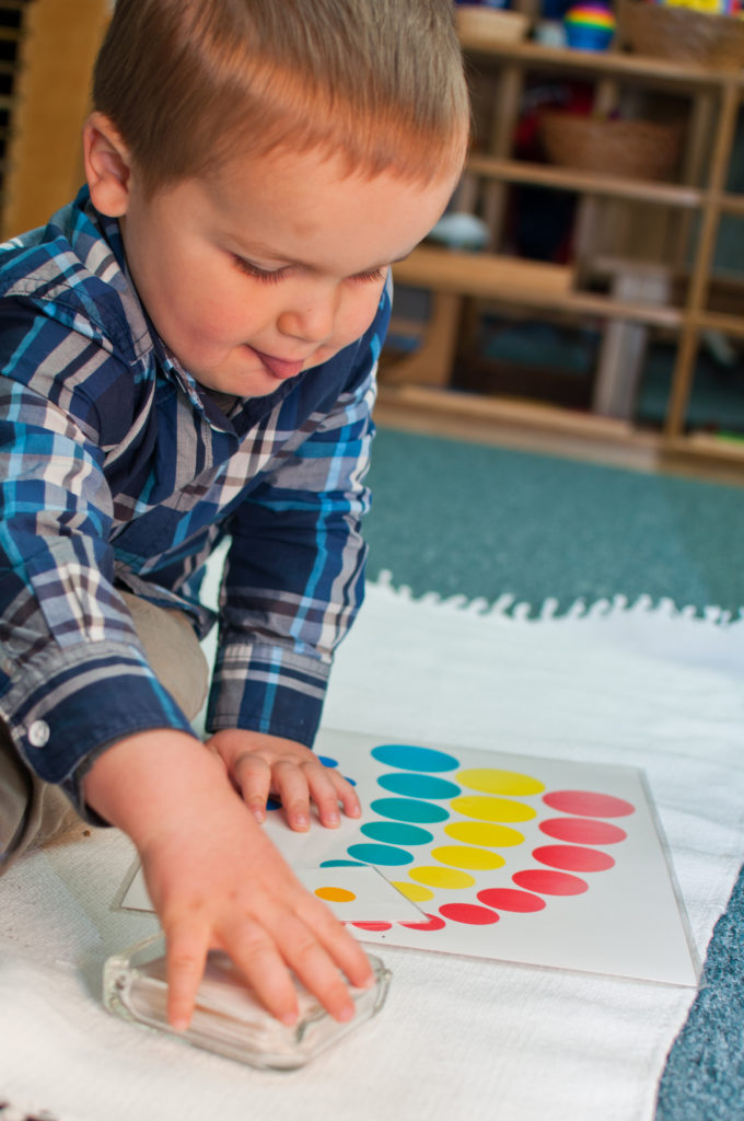 Boy working on sensorial work - New School Montessori Center